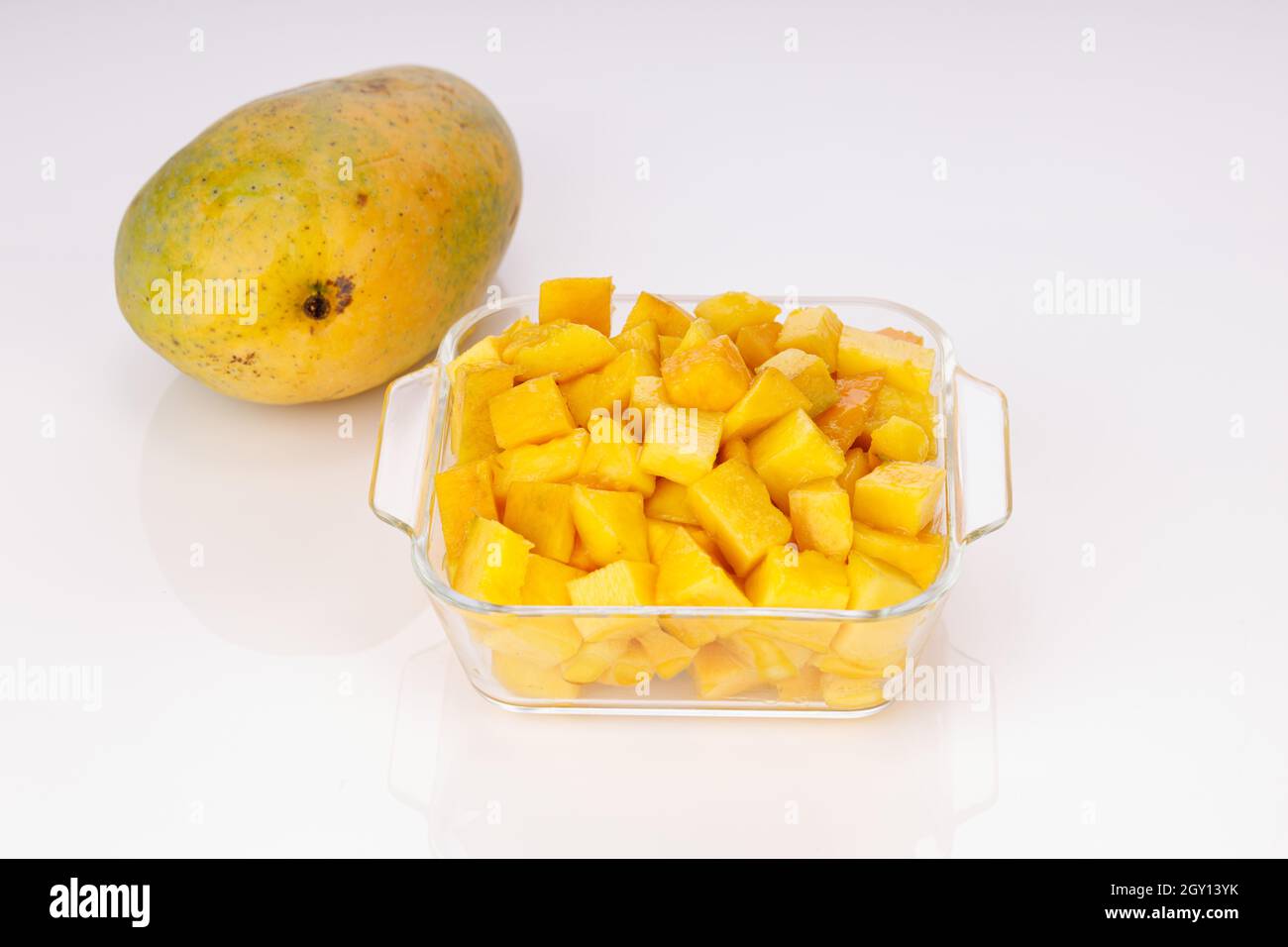 Ripe Mango cubes or cut piece arranged in a glass square container with ...