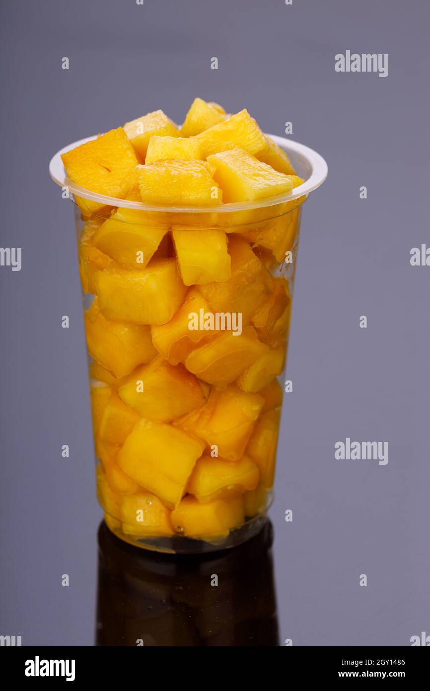 Ripe Mango cubes or cut piece arranged in a transparent glass with ...