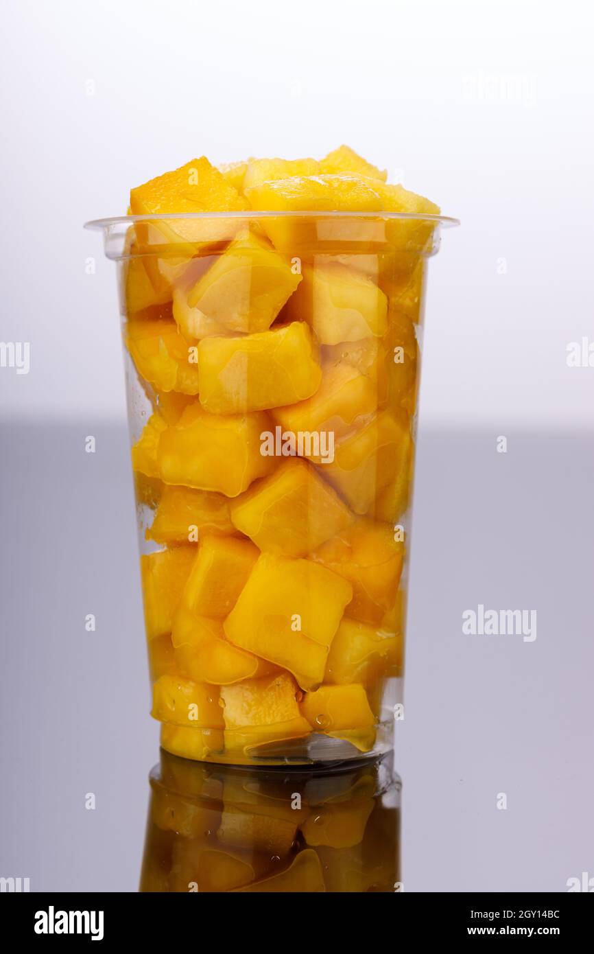 Ripe Mango cubes or cut piece arranged in a transparent glass with ...