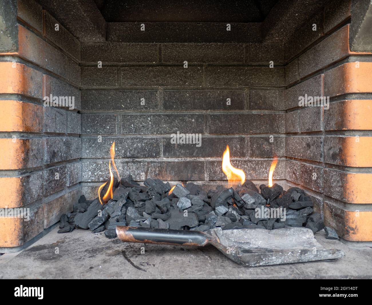 Outdoor fireplace with small burning flames Stock Photo - Alamy