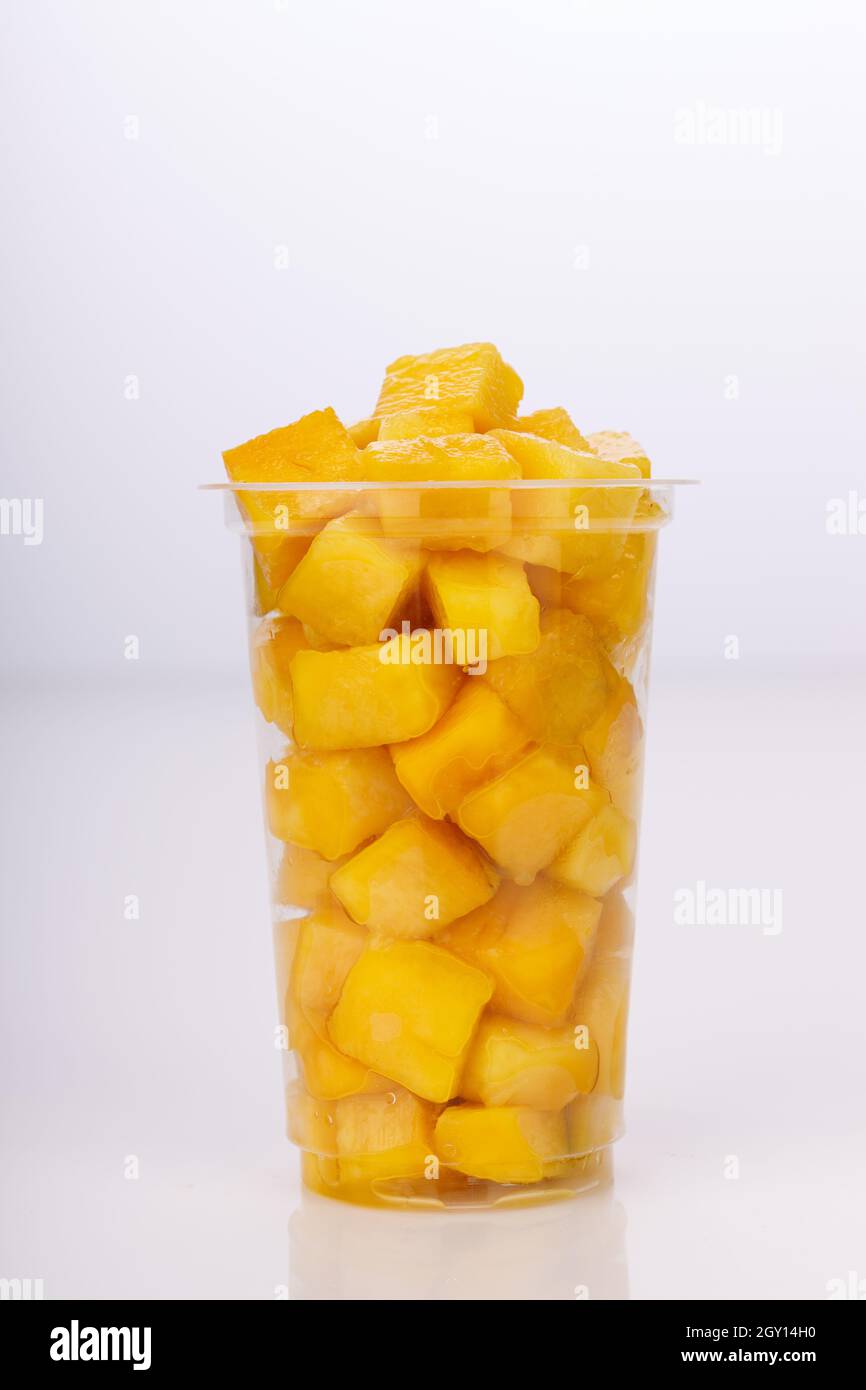 Ripe Mango cubes or cut piece arranged in a transparent glass with ...
