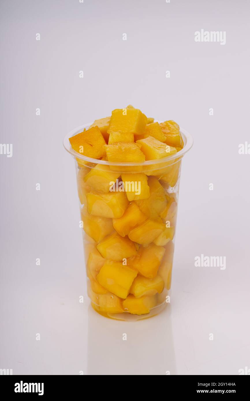 Ripe Mango cubes or cut piece arranged in a transparent glass with ...