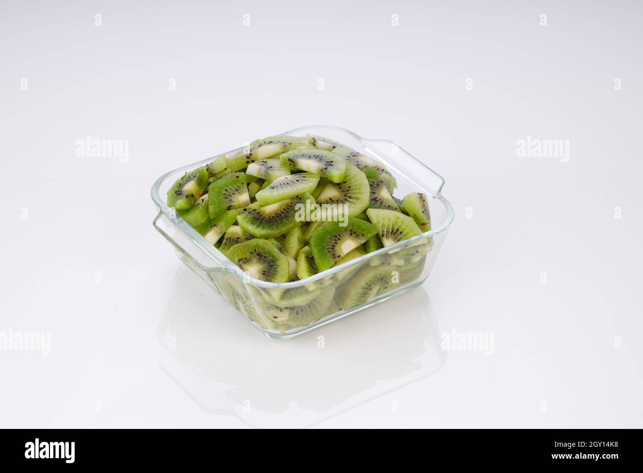Kiwi fruit slices or cut piece arranged in a glass square container ...