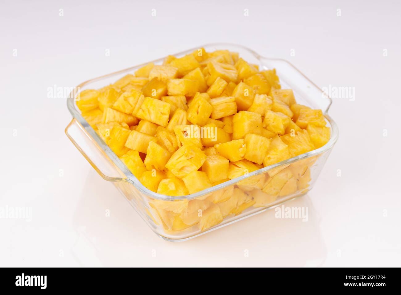 Pineapple cubes arranged in transparent glass square container with ...