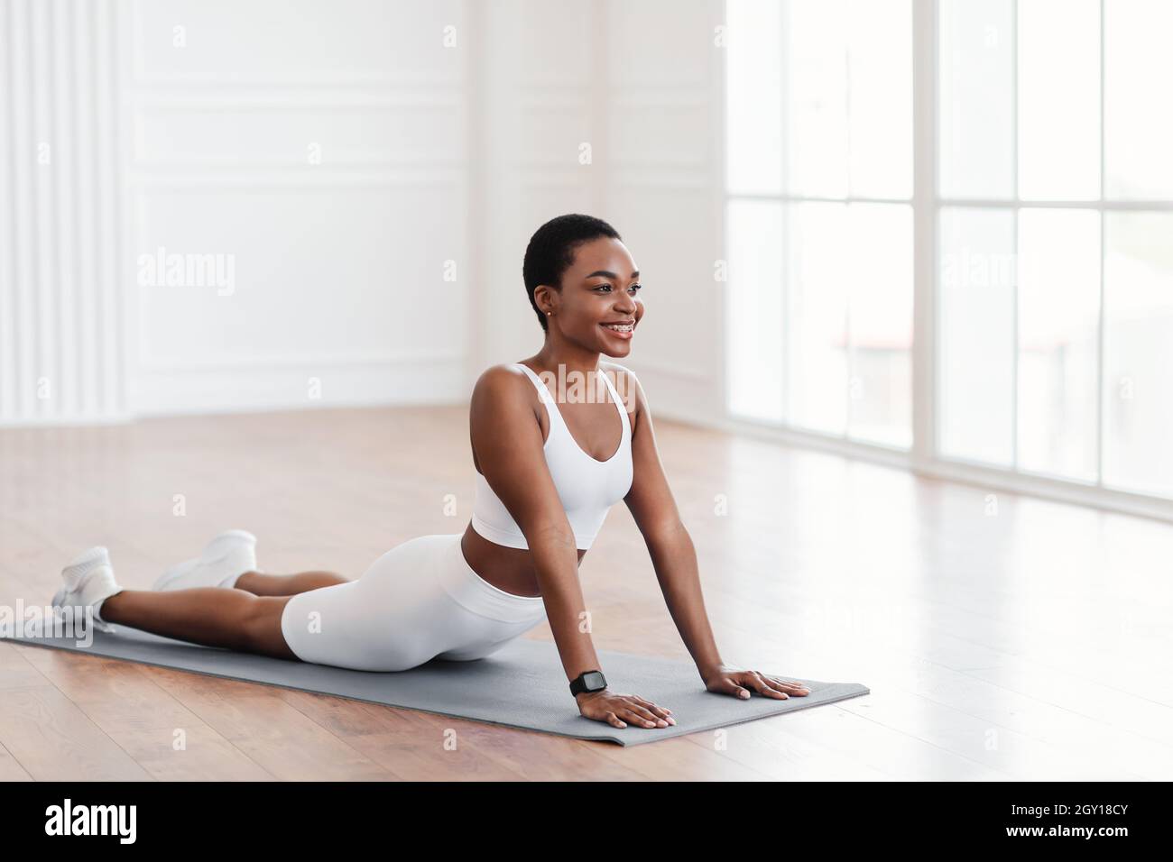 Young black woman stretching back on mat in cobra pose Stock Photo - Alamy