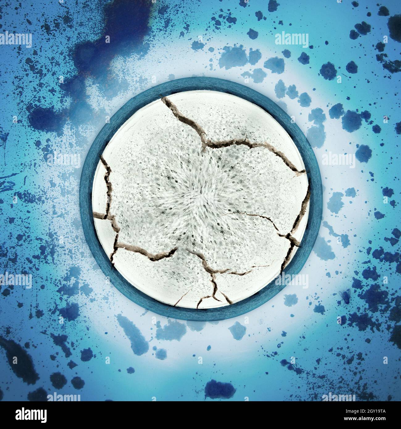Abstract textured white cracking circle superimposed on a blue speckled ...
