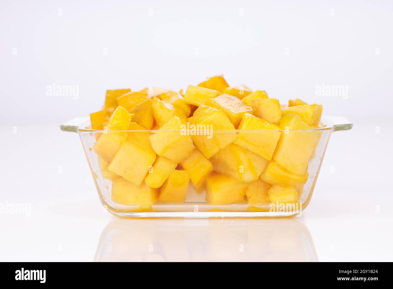 Ripe Mango cubes or cut piece arranged in a glass square container with ...
