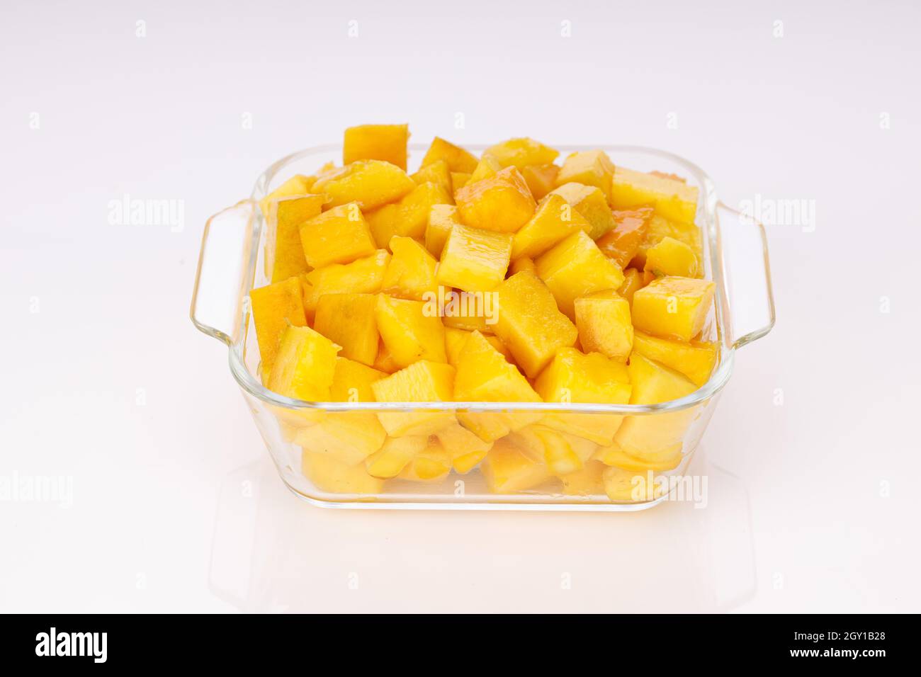 Ripe Mango cubes or cut piece arranged in a glass square container with ...