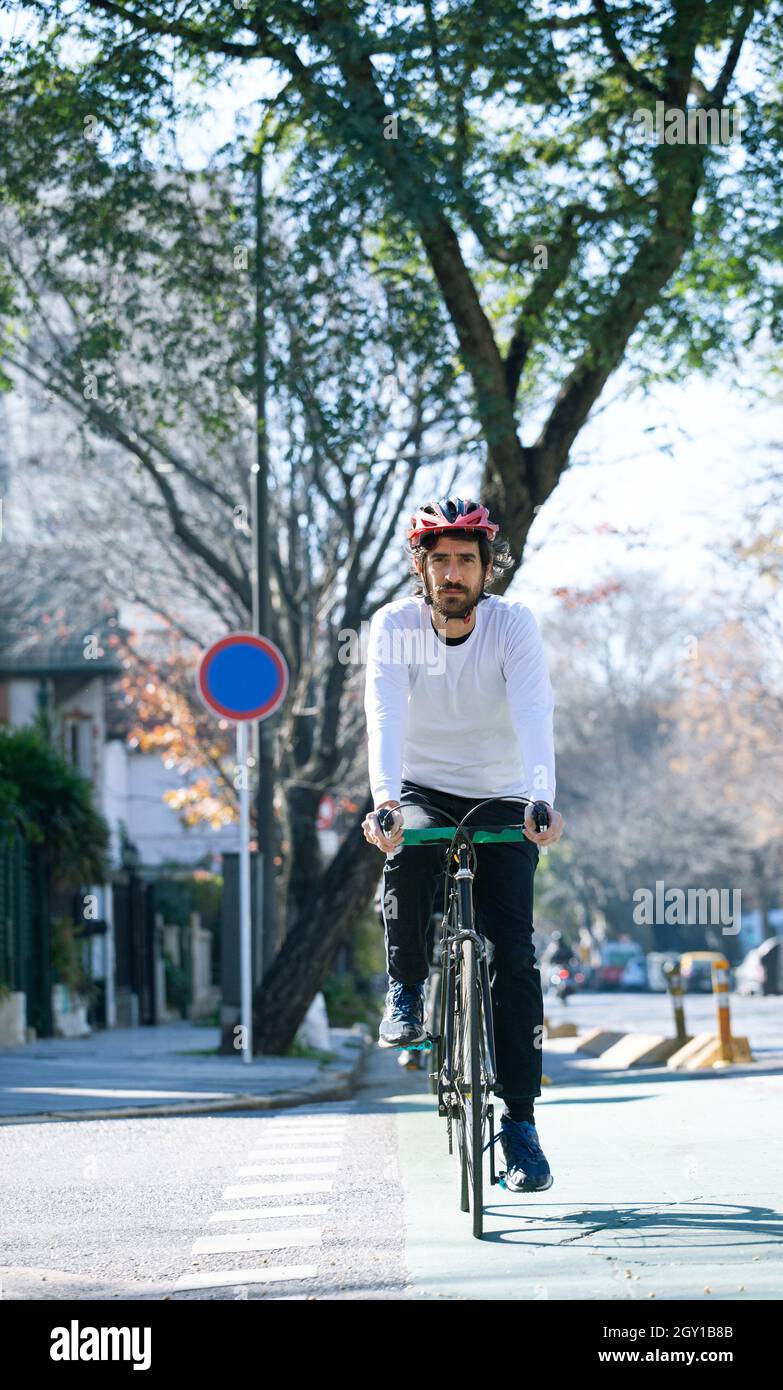 Vertical shot of a Caucasian male riding a bike in the morning Stock Photo - Alamy