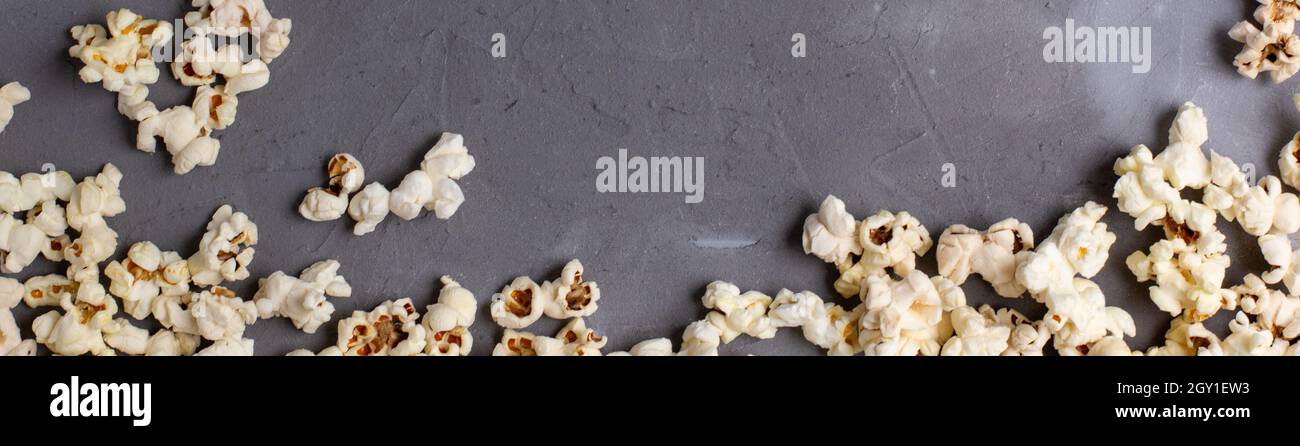 banner of Border of fresh popcorn on grey stone background. Top view ...