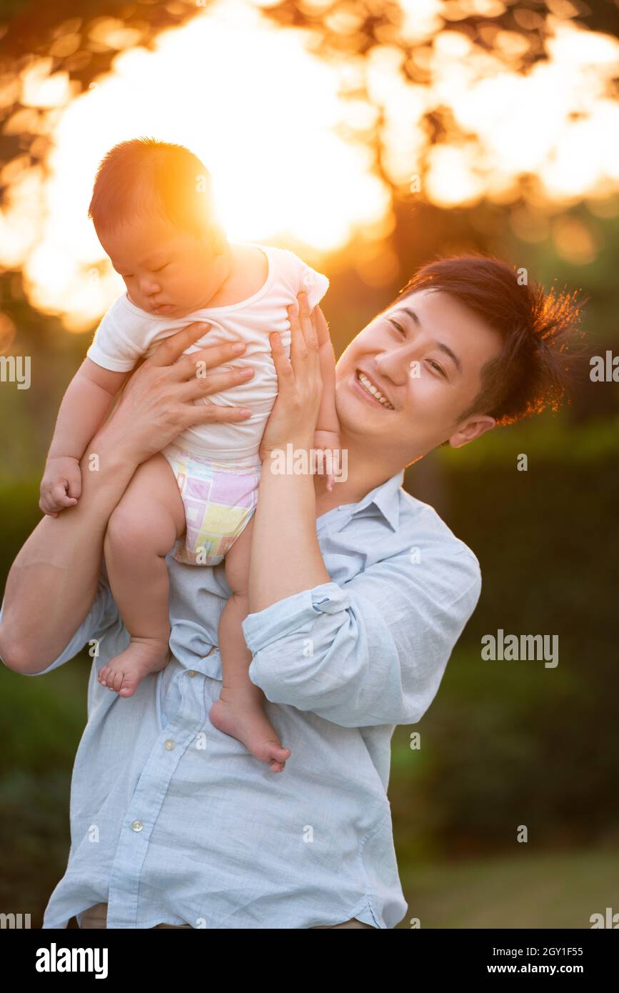 Young father raising his baby to play Stock Photo - Alamy