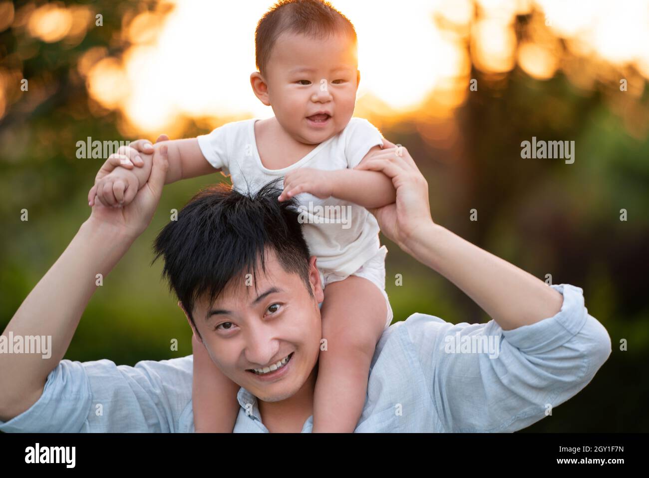 Young father raising his baby to play Stock Photo - Alamy