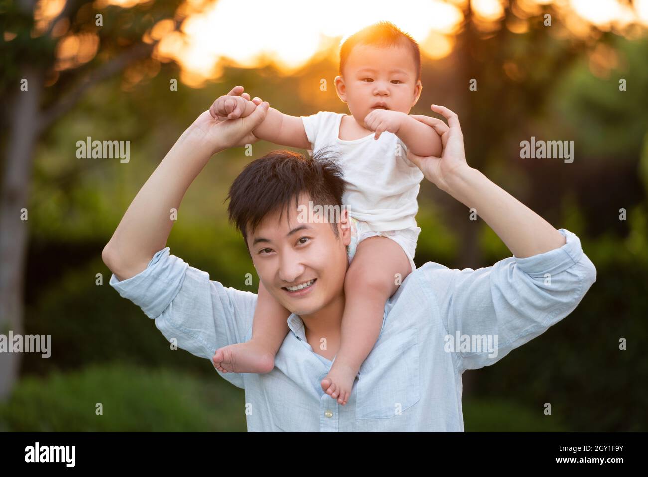 Young father raising his baby to play Stock Photo - Alamy
