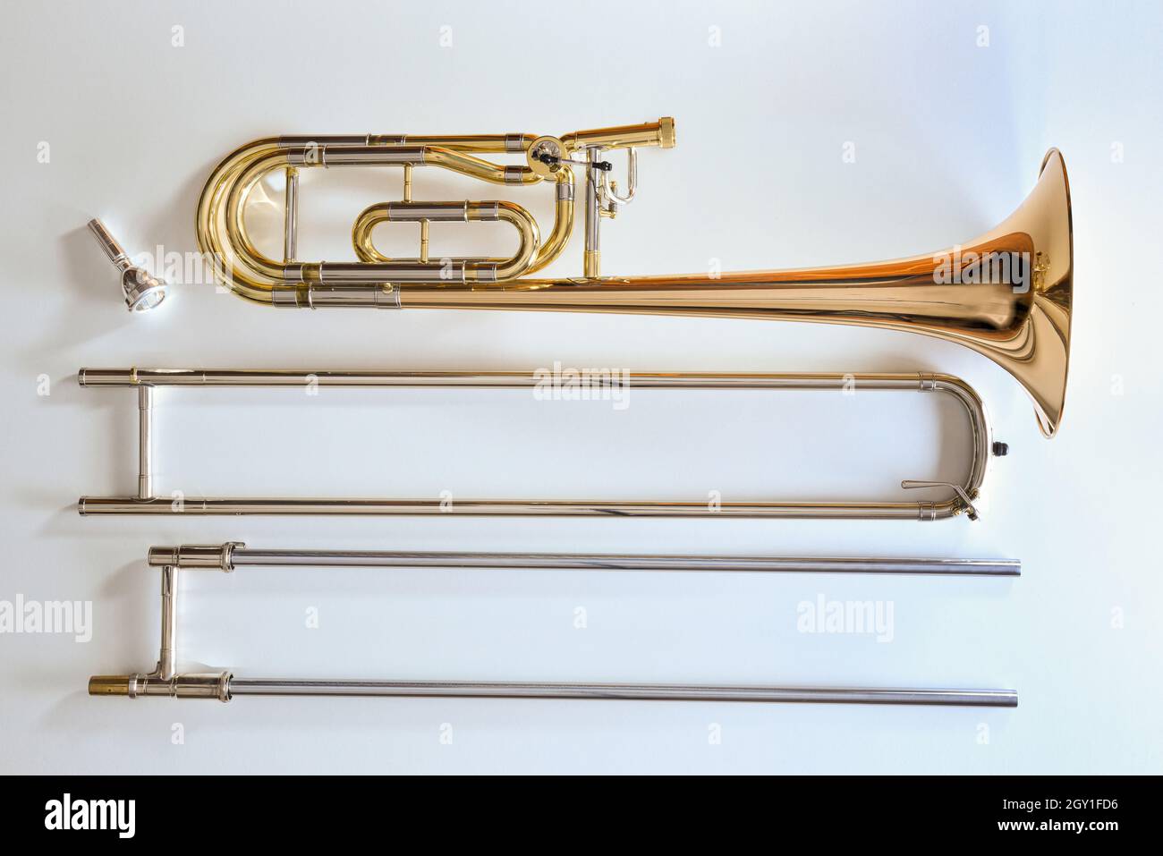 Trombone with transposer disassembled on a white table. Top view ...