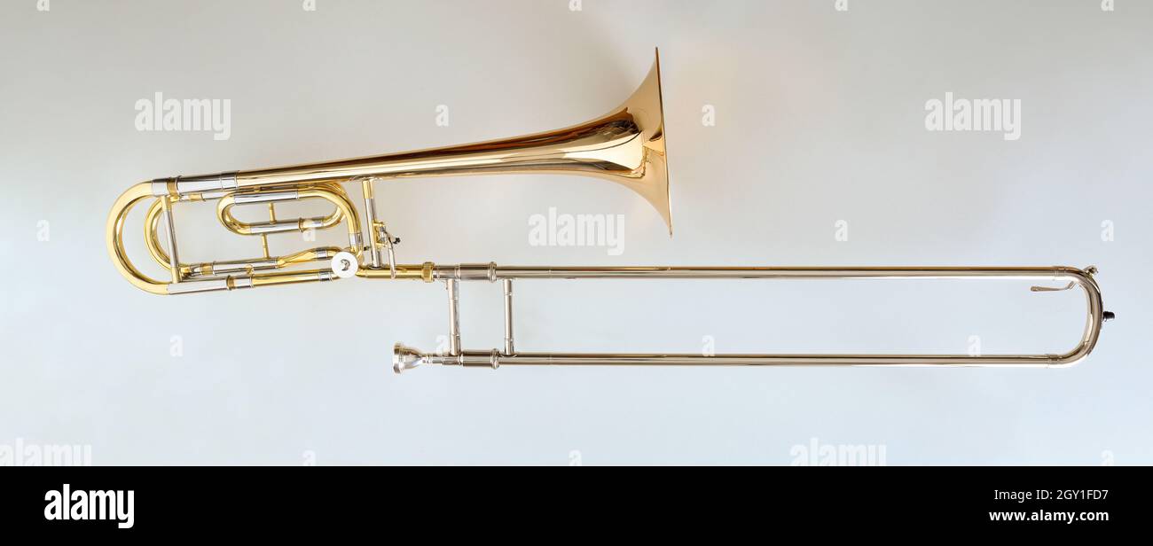 Trombone with transposer mounted on a white table. Top view. Horizontal ...