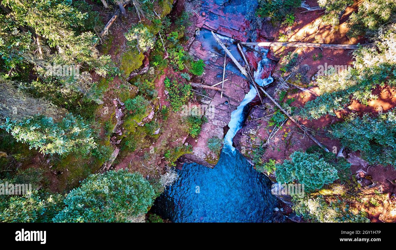 Aerial looking down at deep gorge with narrow river and mossy rock ...