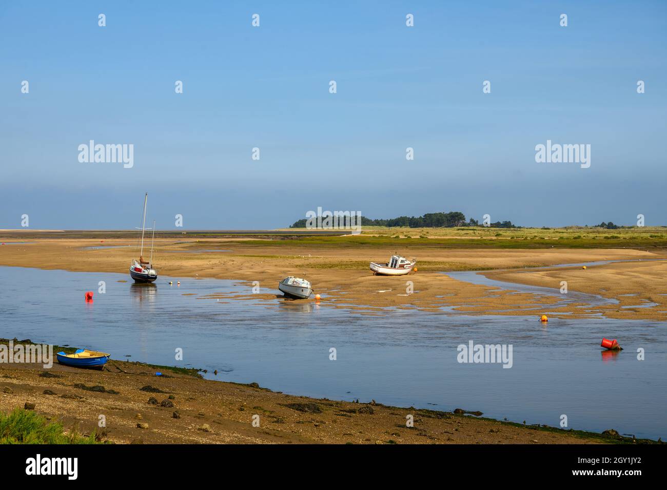 Boats sitting on the riverbed during low tide on East Fleet river with ...