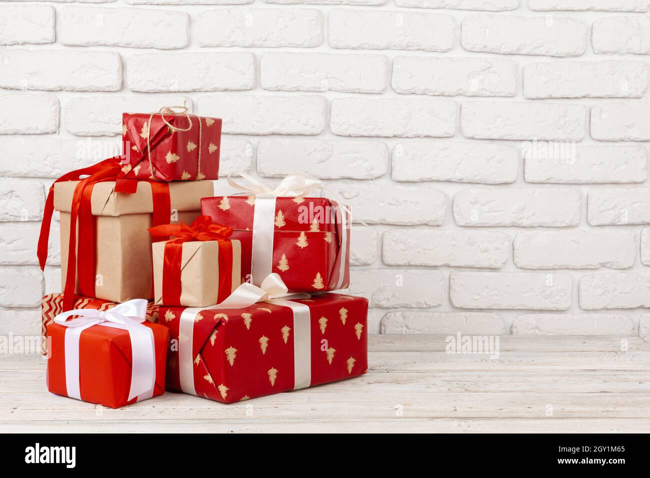 Colorful gift boxes against white brick wall background Stock Photo - Alamy