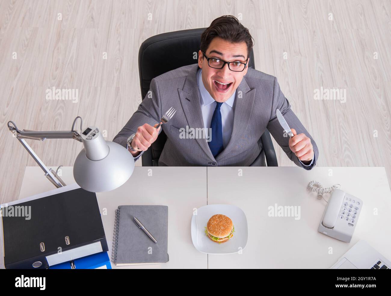 The hungry funny businessman eating junk food sandwich Stock Photo - Alamy