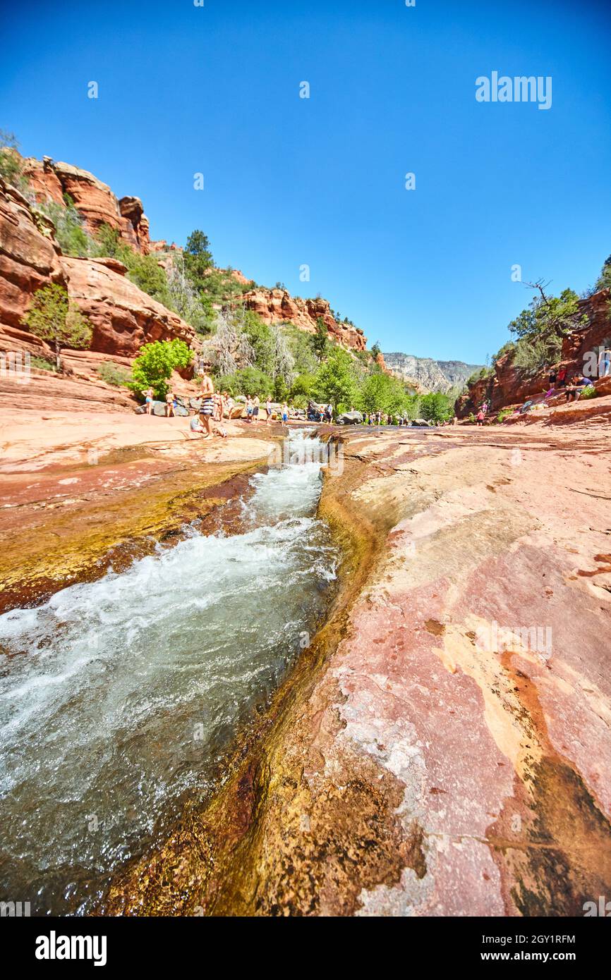 Tourists in red rock canyon with rapids river water running slide Stock ...