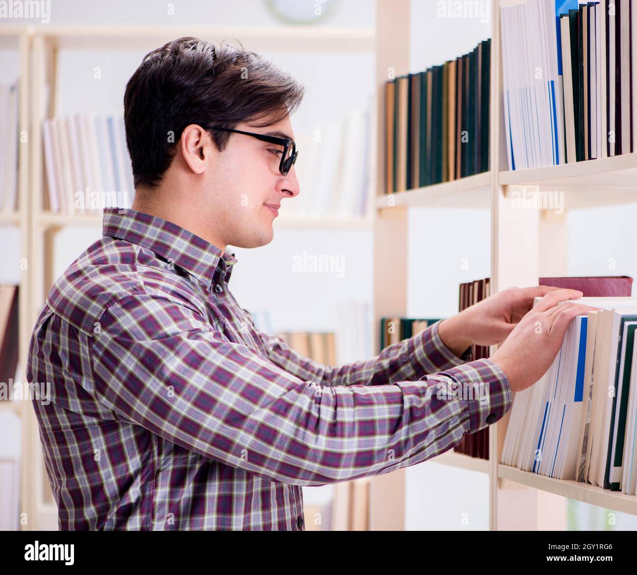 The young student looking for books in college library Stock Photo - Alamy