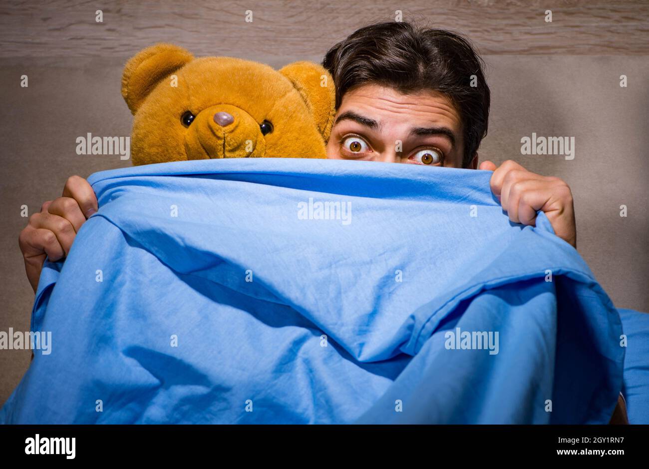 The young man scared in bed Stock Photo - Alamy