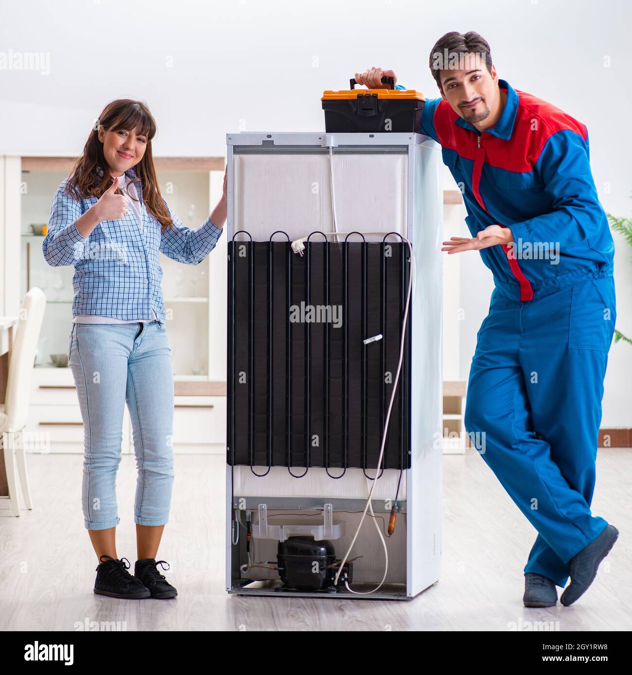 The man repairing fridge with customer Stock Photo - Alamy