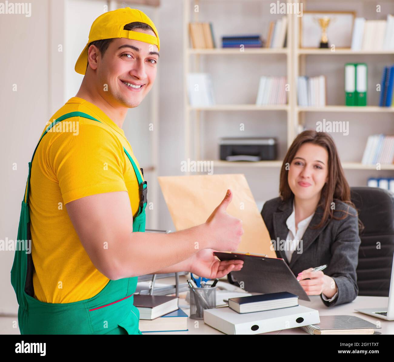 The postman delivering parcel to the office Stock Photo - Alamy