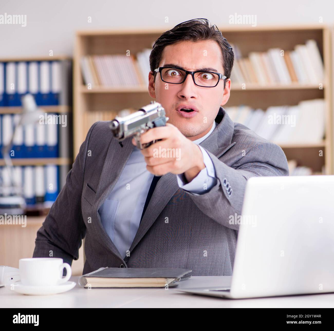 The funny businessman with gun in office Stock Photo - Alamy