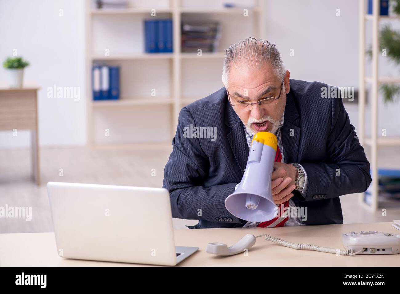 Angry boss holding megaphone in the office Stock Photo - Alamy