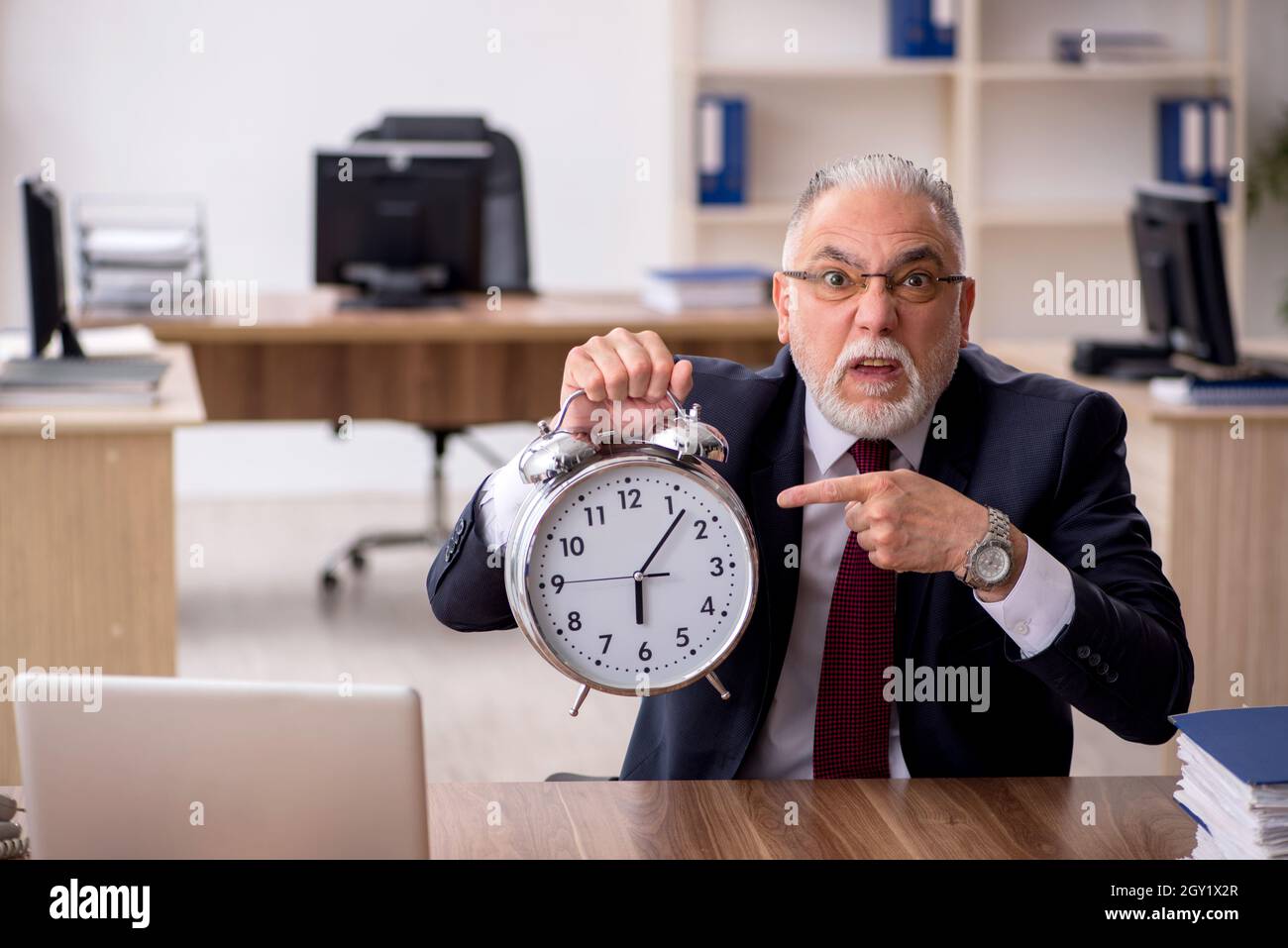 Old employee in time management concept Stock Photo - Alamy