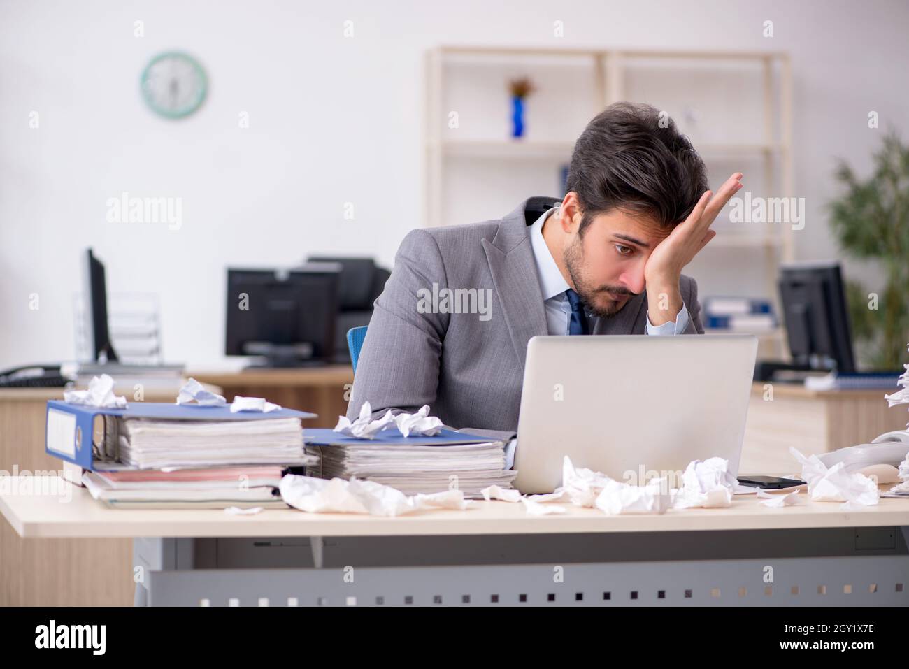 Young employee and too much work in the office Stock Photo - Alamy