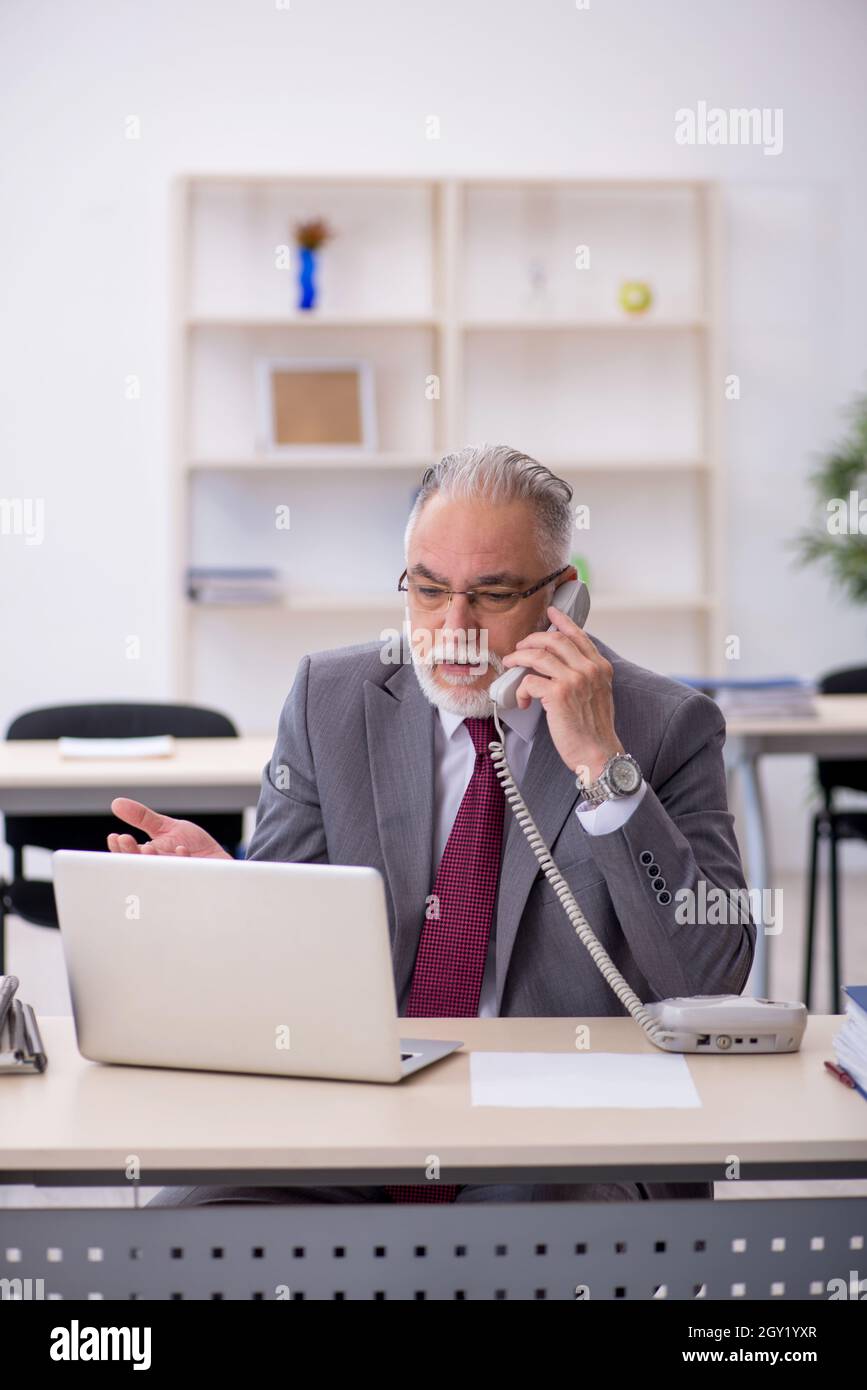 Old employee working in the office Stock Photo - Alamy