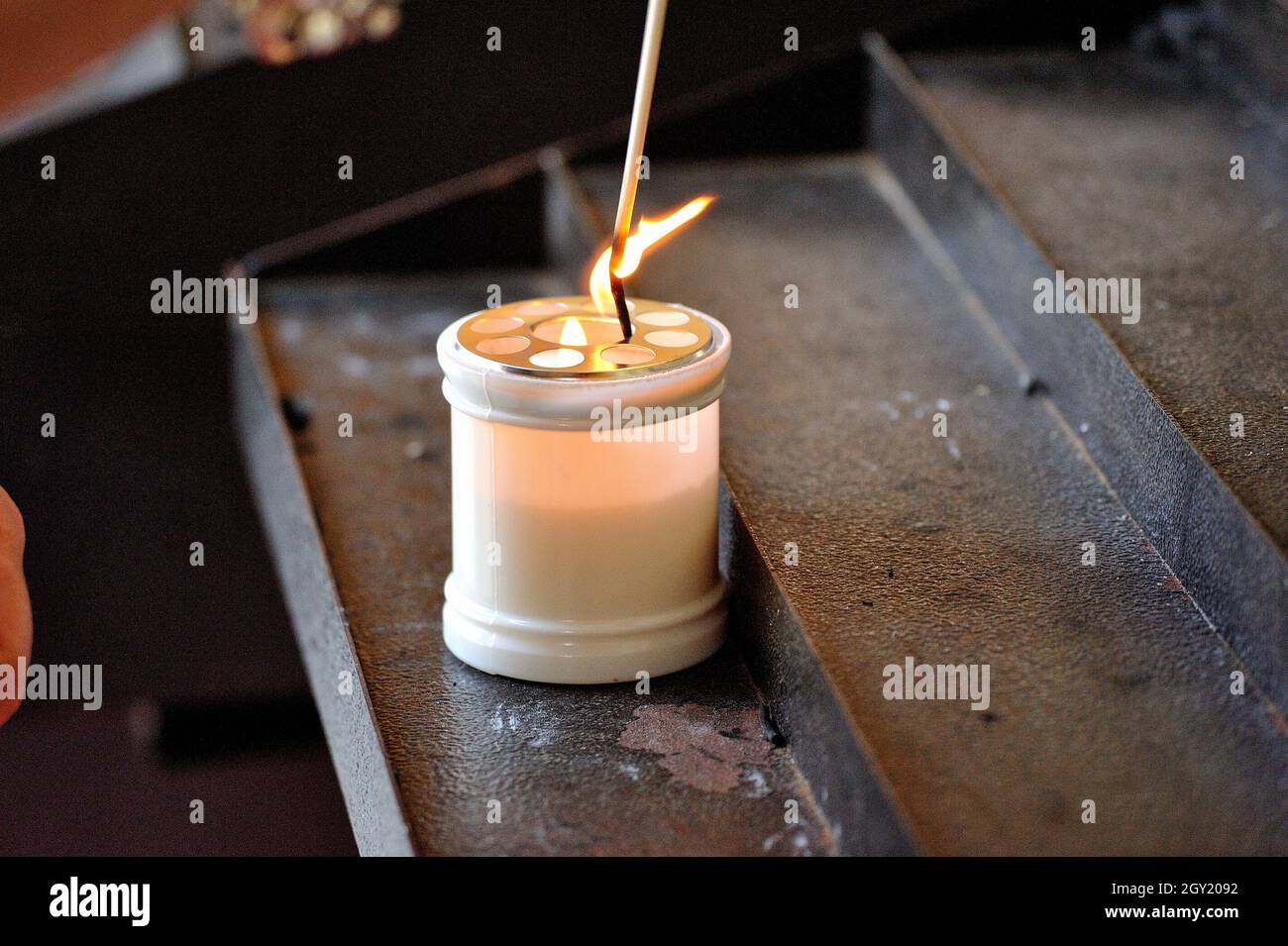 View of a burning candle in a plastic jar on a metal staircase ...