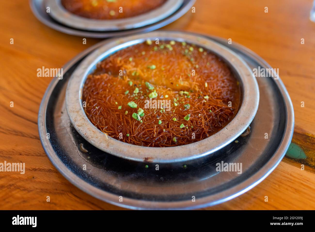 Turkish dessert kunefe, kunafa, kadayif with pistachio powder and ...