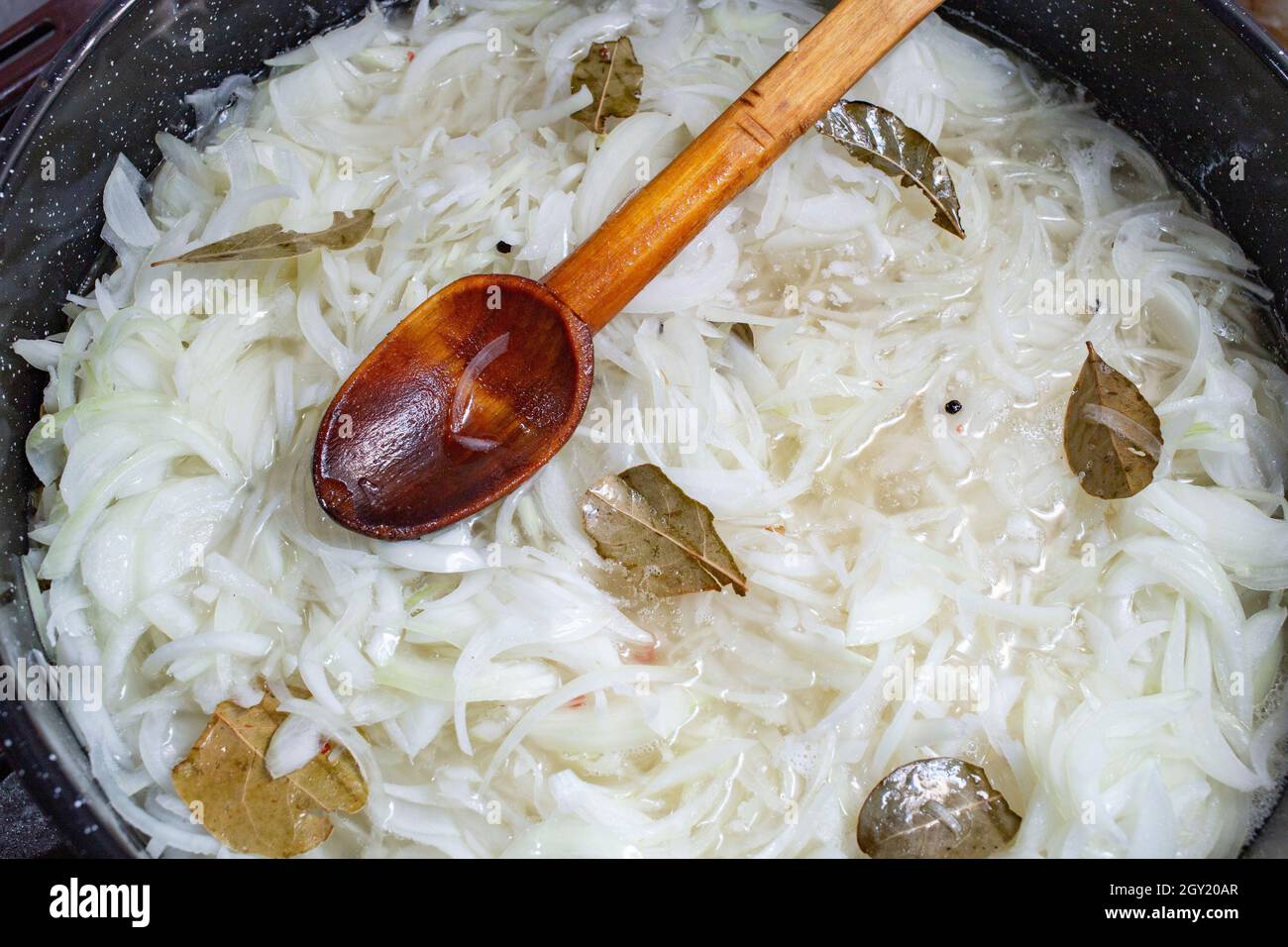 pot full of sliced onions boiling with bay leaves and pepper Stock ...