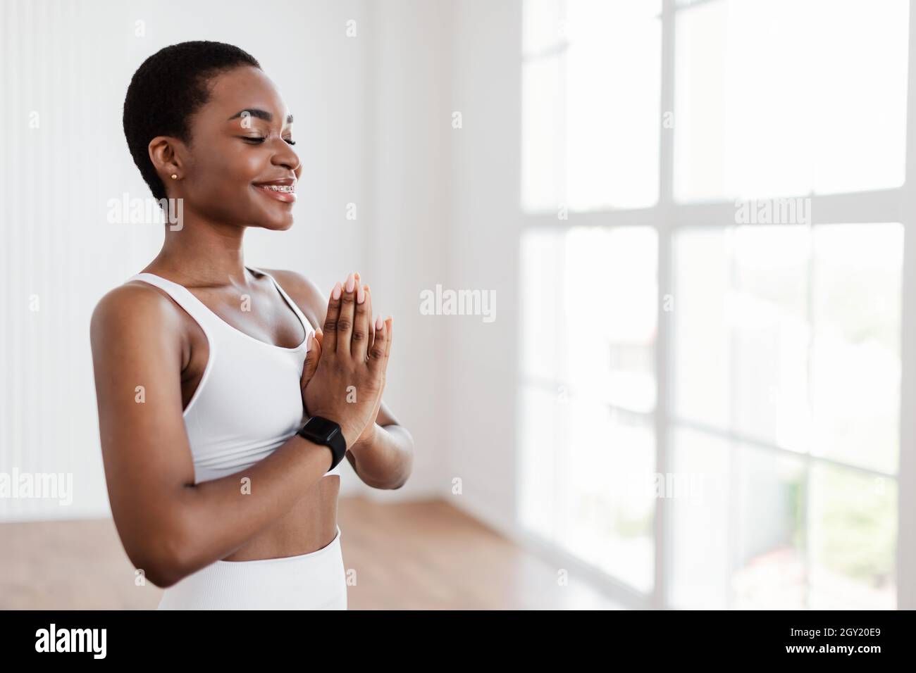 Black woman meditating in prayer pose with closed eyes Stock Photo - Alamy