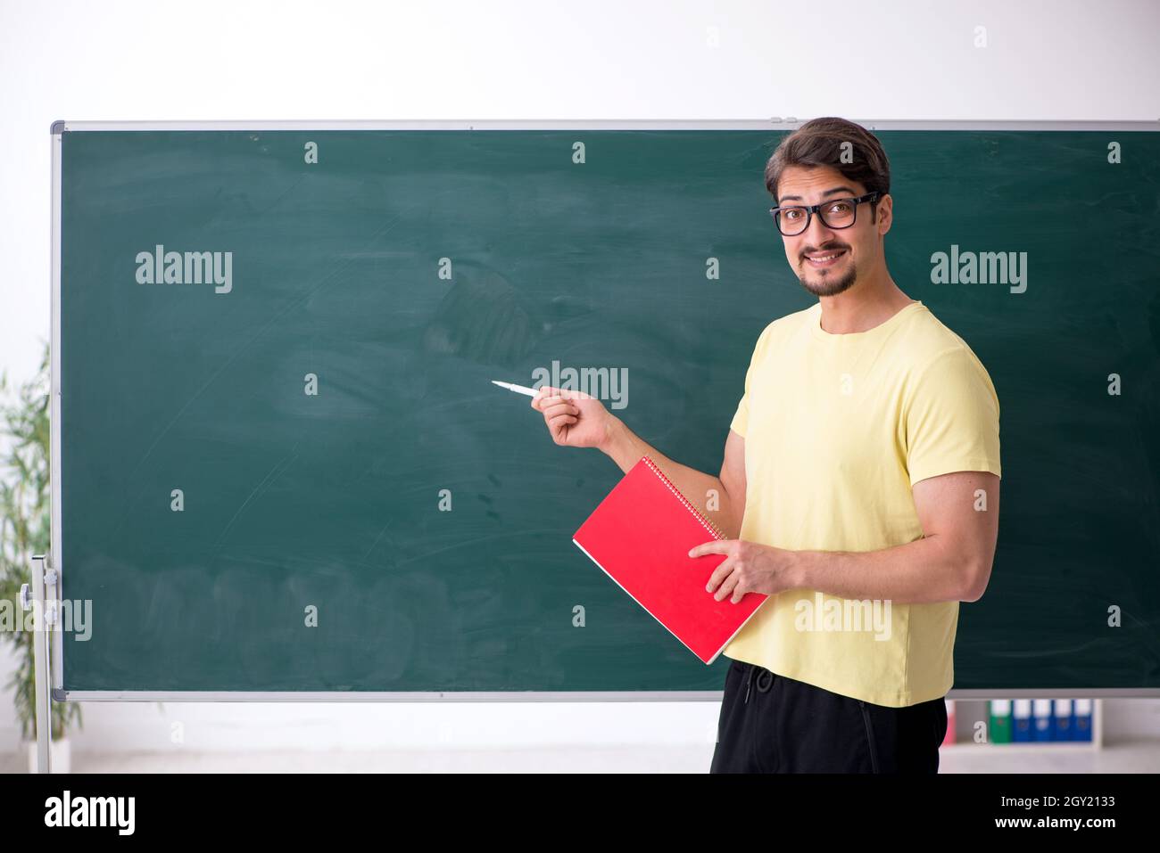 Young student in front of blackboard Stock Photo - Alamy