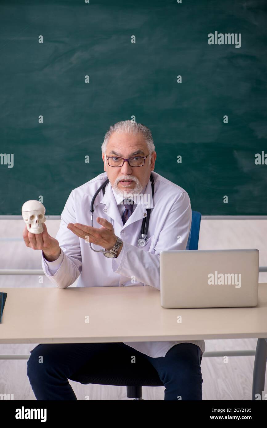 Old doctor teacher in front of blackboard Stock Photo - Alamy