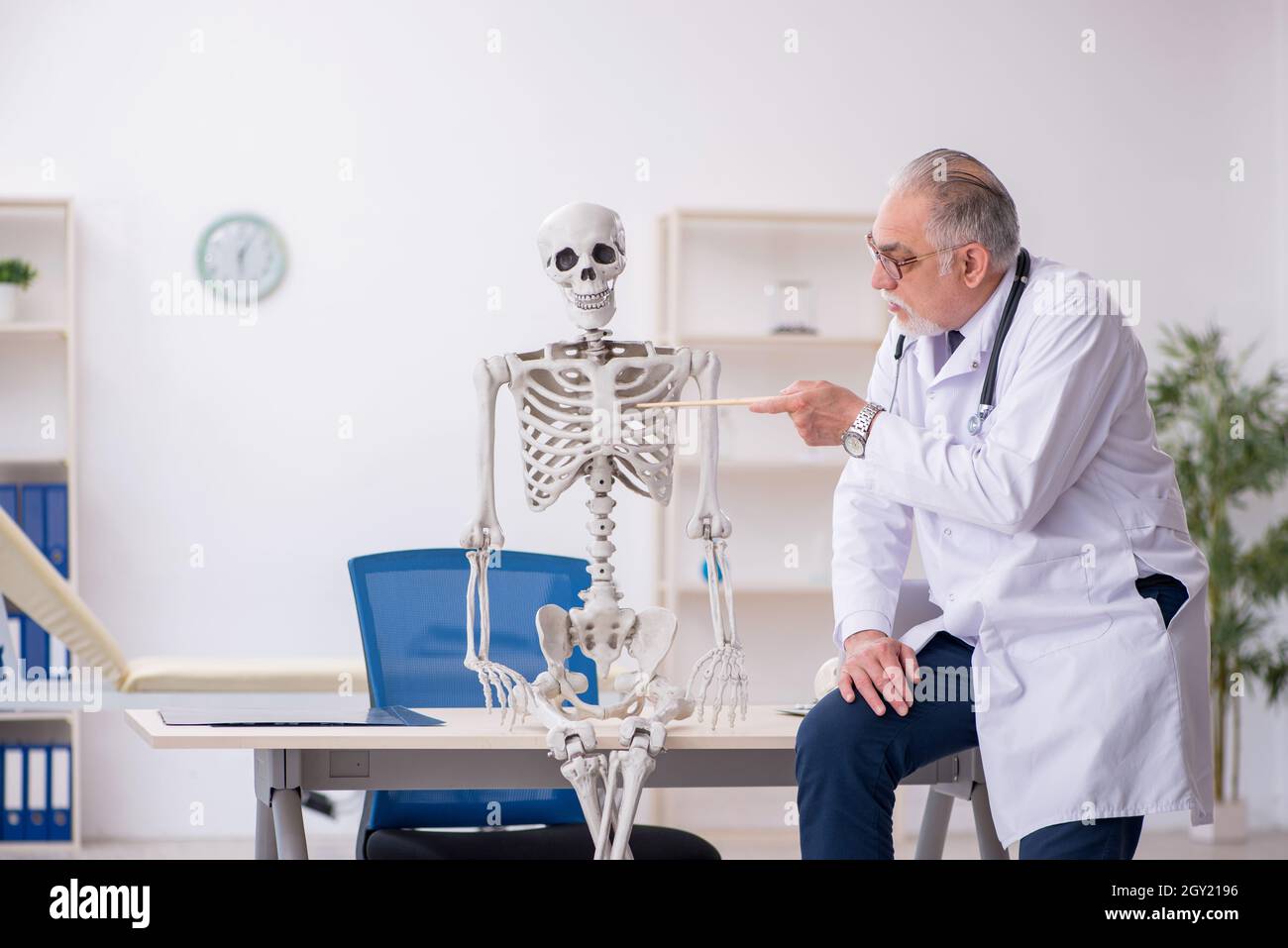 Old doctor demonstrating human skeleton Stock Photo - Alamy