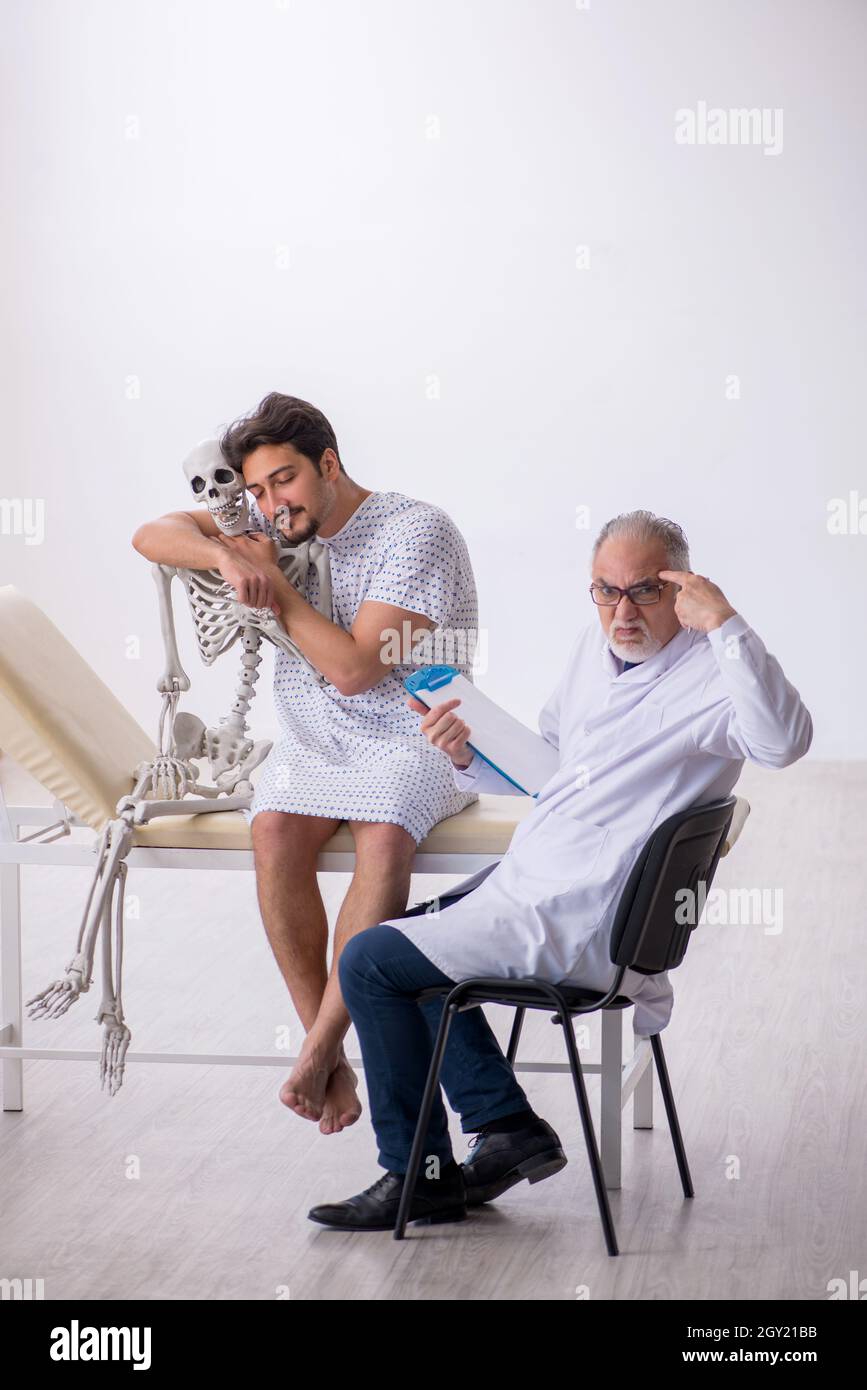Old doctor psychiatrist examining young male patient Stock Photo - Alamy
