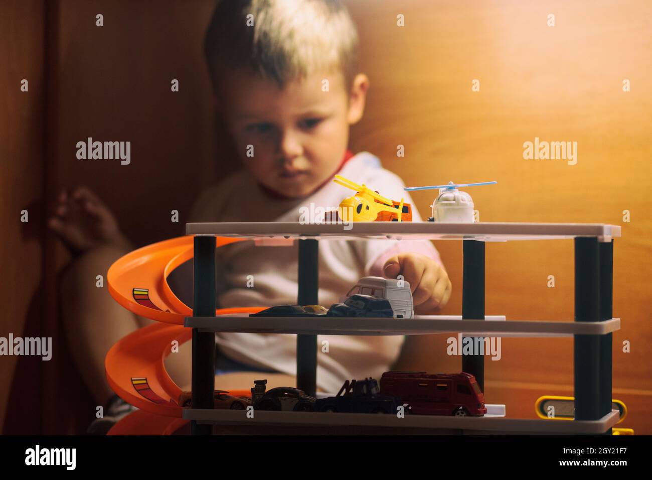 Little boy playing toy cars. Child driving car to parking garage. Kids ...