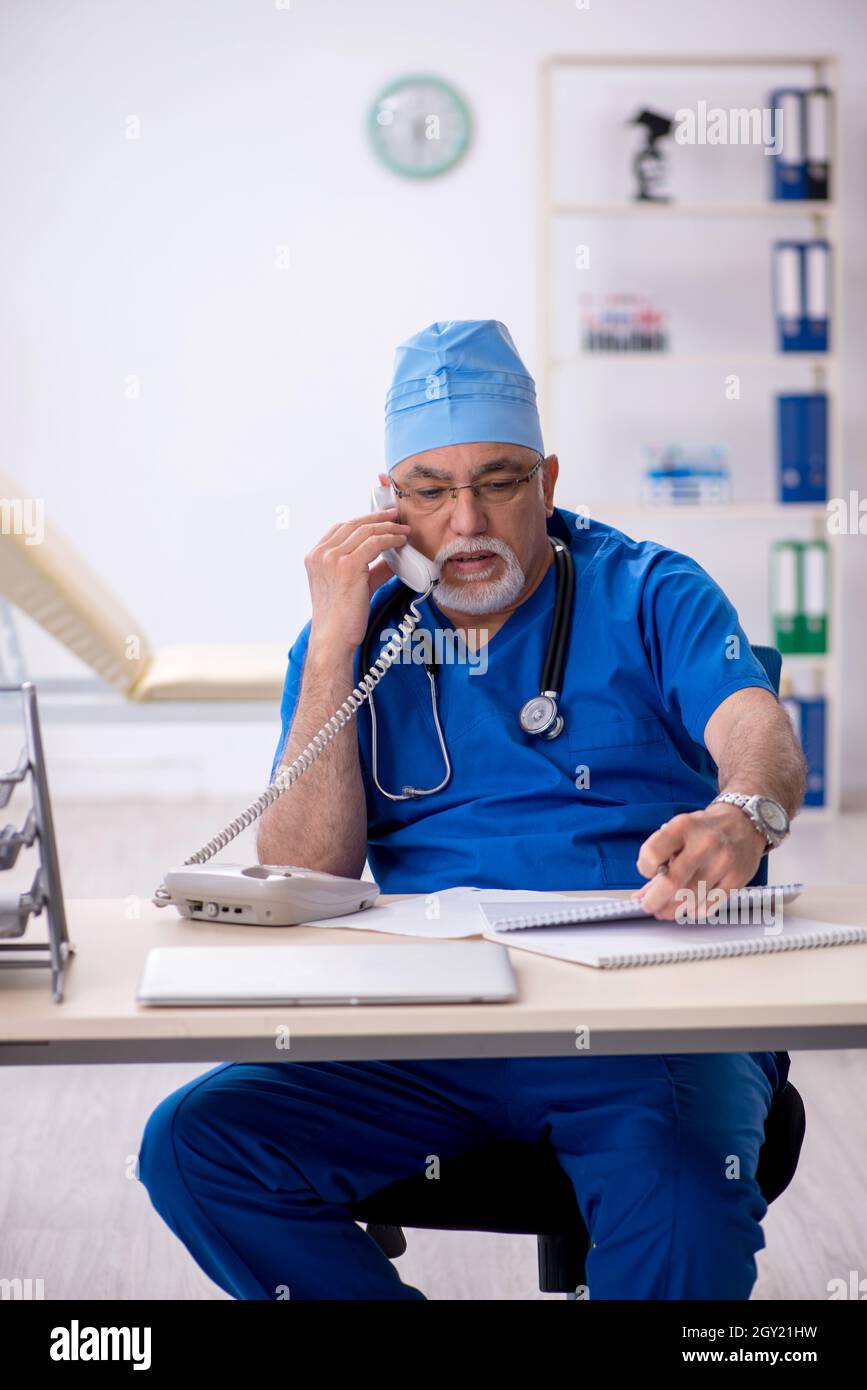 Old doctor working in the clinic Stock Photo - Alamy