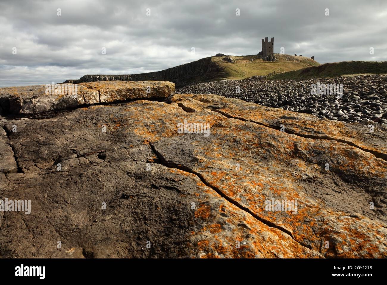 Rocks in Embleton Bay north of the 14th century Dunstanburgh Castle ...