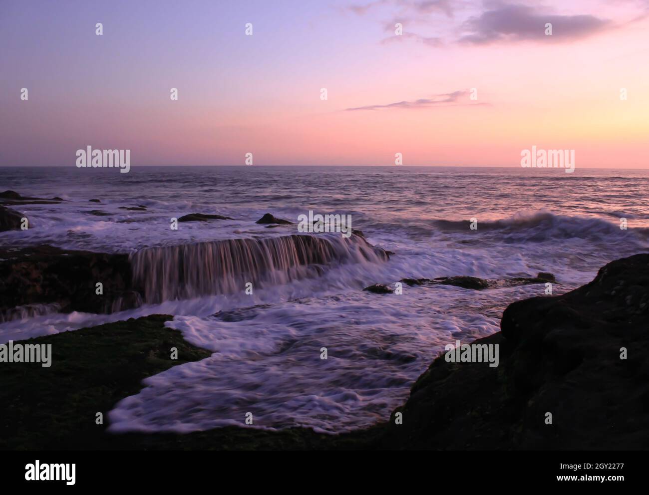 Picturesque view of a wavy sea with a little waterfall during an ...