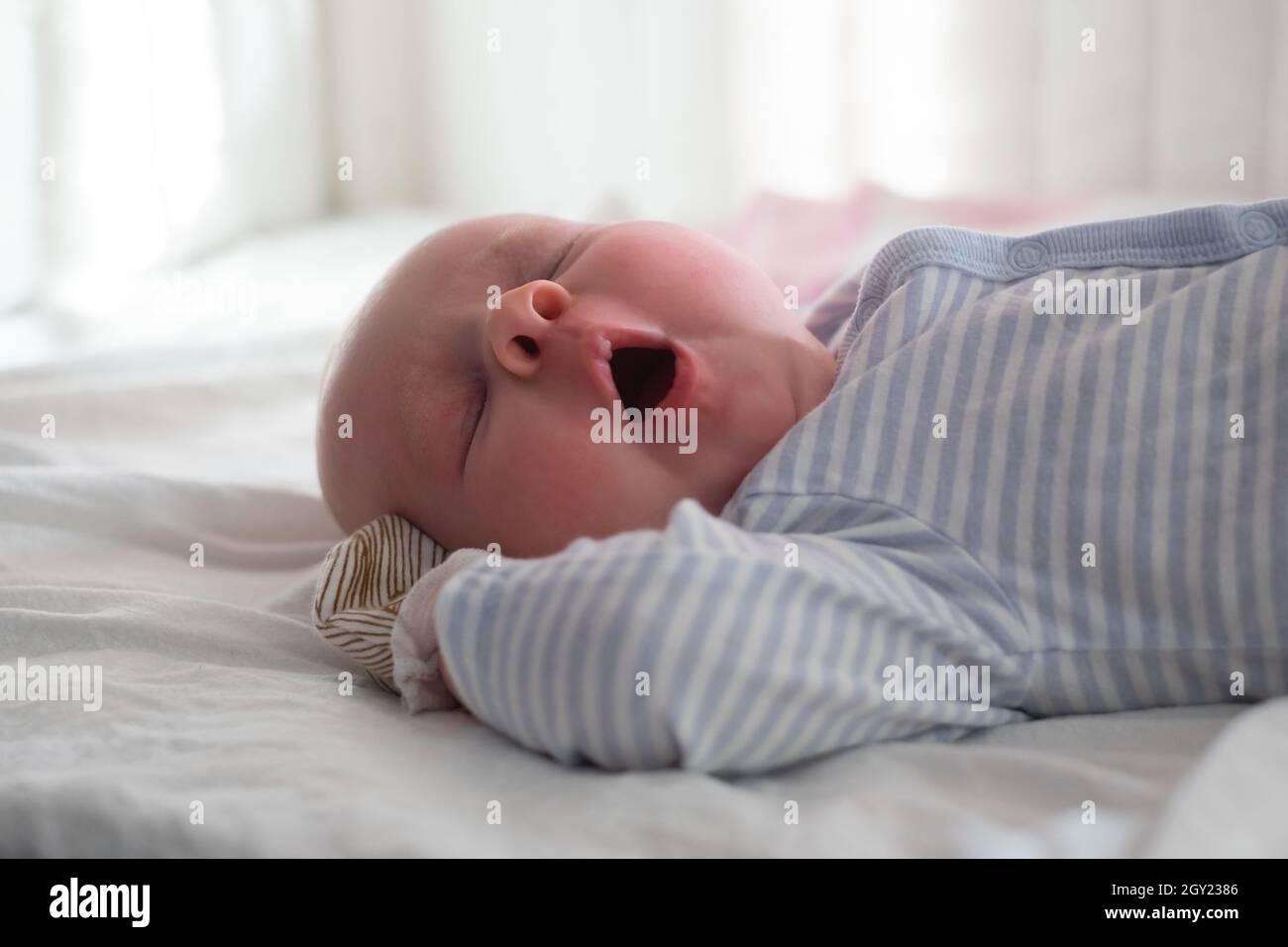 Yawning baby waking up at the morning Stock Photo - Alamy