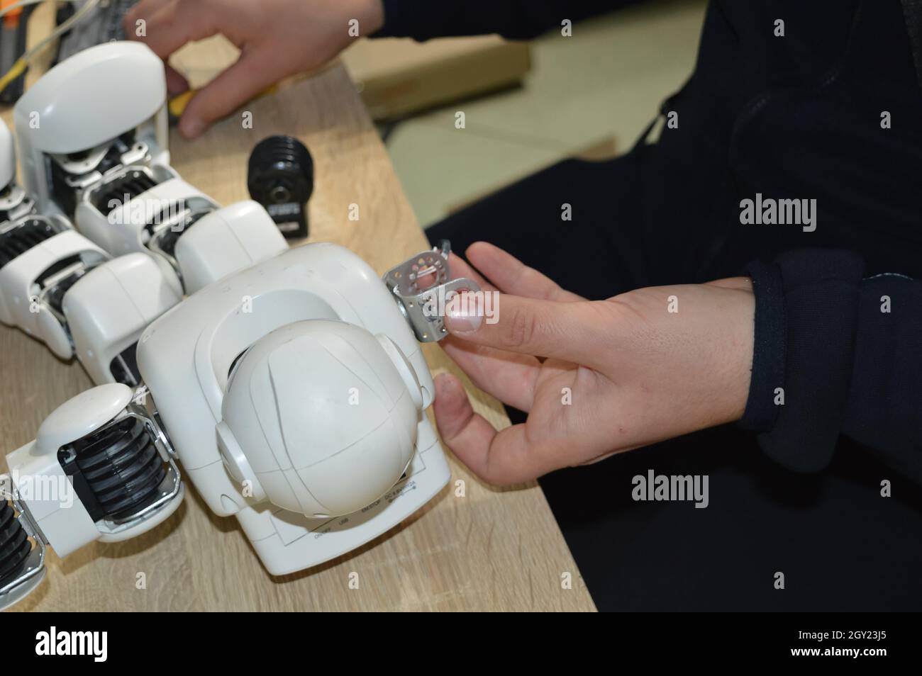 man repairing a robot. Close up of male hands fixing a broken little ...