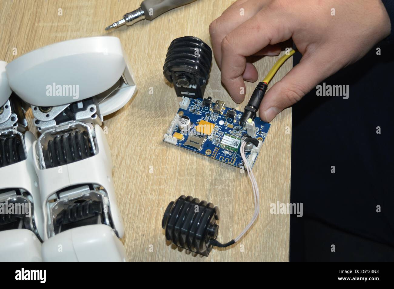man repairing a robot. Close up of male hands fixing a broken little ...