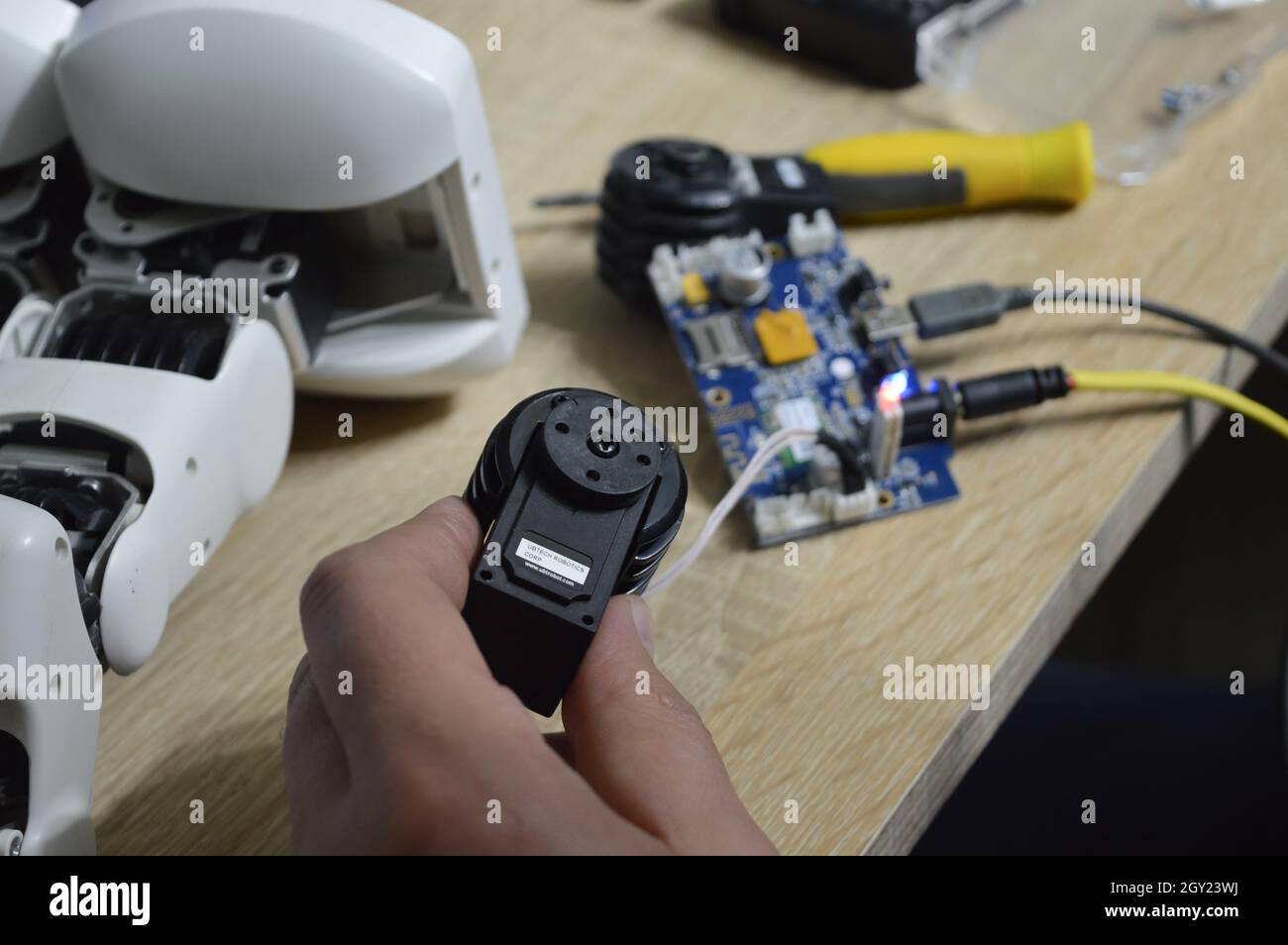 man repairing a robot. Close up of male hands fixing a broken little ...