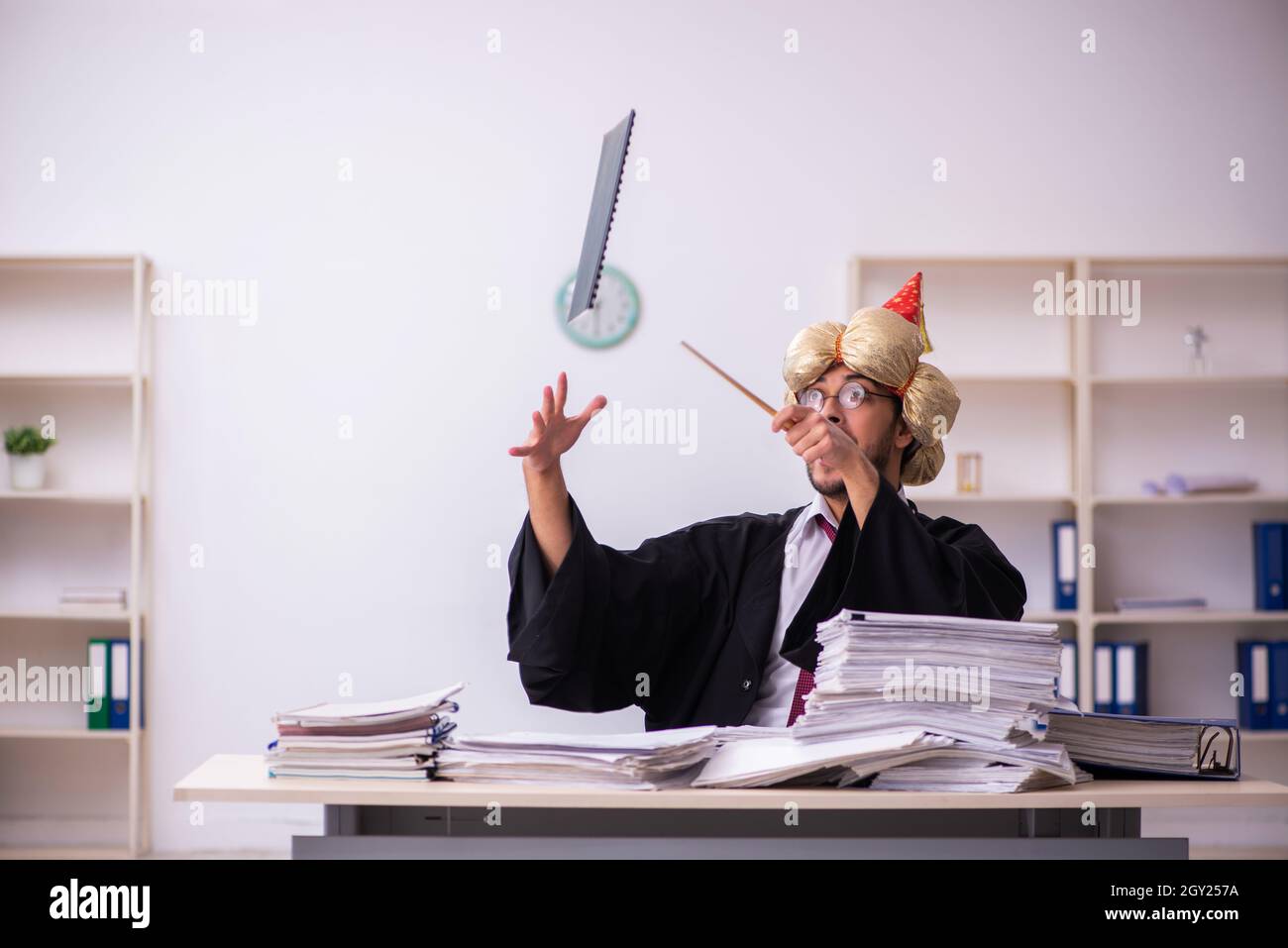 Funny young employee magician and too much work in the office Stock ...